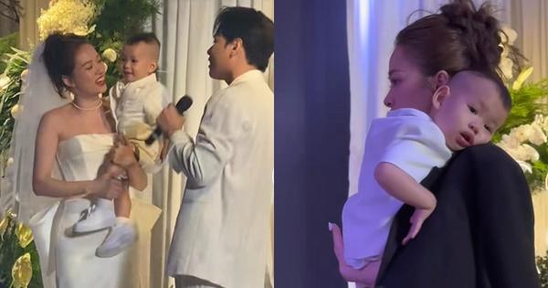 Đang diện váy cô dâu, vợ JayKii xả vai bồng con ngủ giữa đám cưới